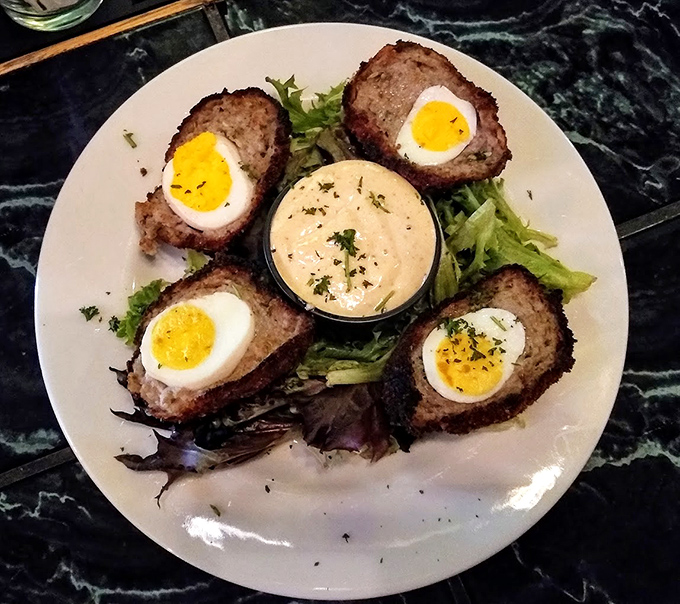 Scotch eggs done proper – crispy exterior giving way to savory sausage and that perfect soft-boiled center. Pub food elevated to an art form.