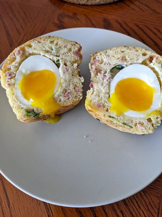 Breakfast engineering at its finest—soft-boiled eggs nestled in savory muffins create the ultimate portable morning meal.