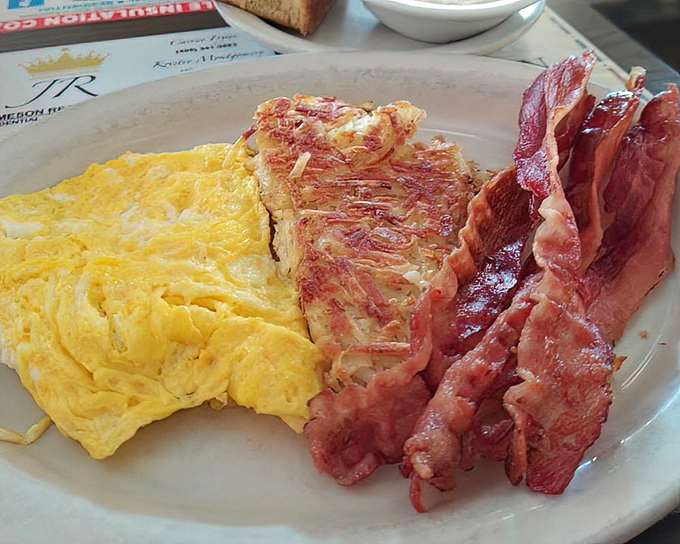 The classic American breakfast in all its glory – eggs cooked just right, bacon with that perfect crisp, and toast standing by for yolk-sopping duty.