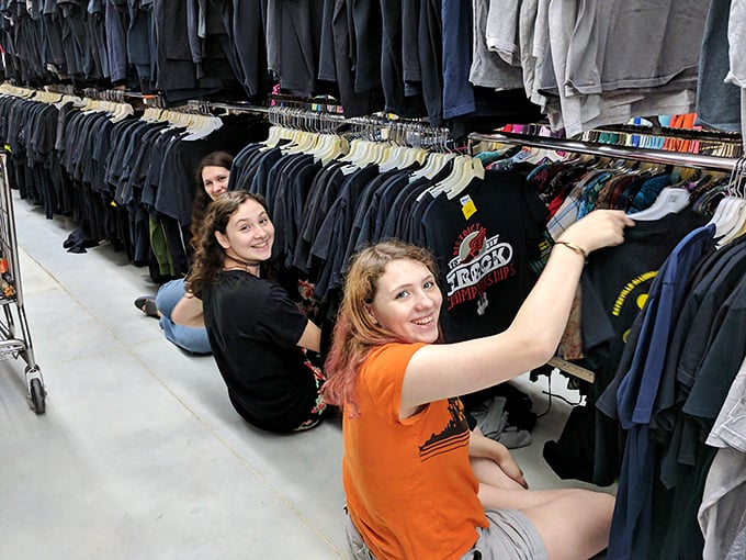 The true thrill of thrifting captured – shoppers diving deep into racks, experiencing that universal joy of discovering hidden gems among the hangers.