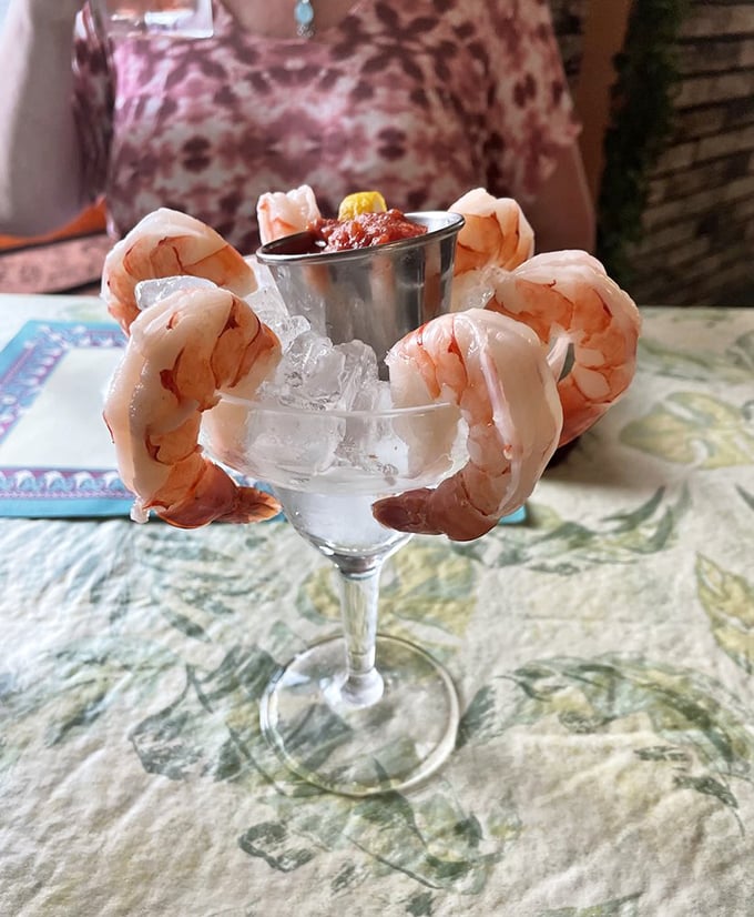 Shrimp cocktail that means business—plump crustaceans hanging off the glass like they're trying to escape their delicious fate. The cocktail sauce awaits its moment.