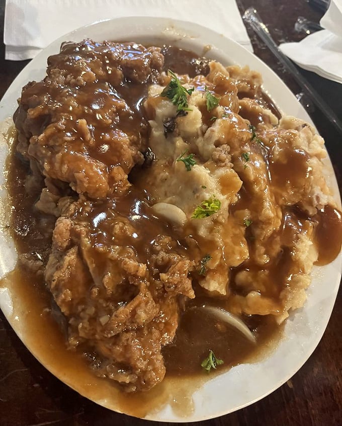 Smothered chicken and mashed potatoes drowning in gravy—the kind of dish that makes you want to cancel your afternoon plans for a well-deserved nap.