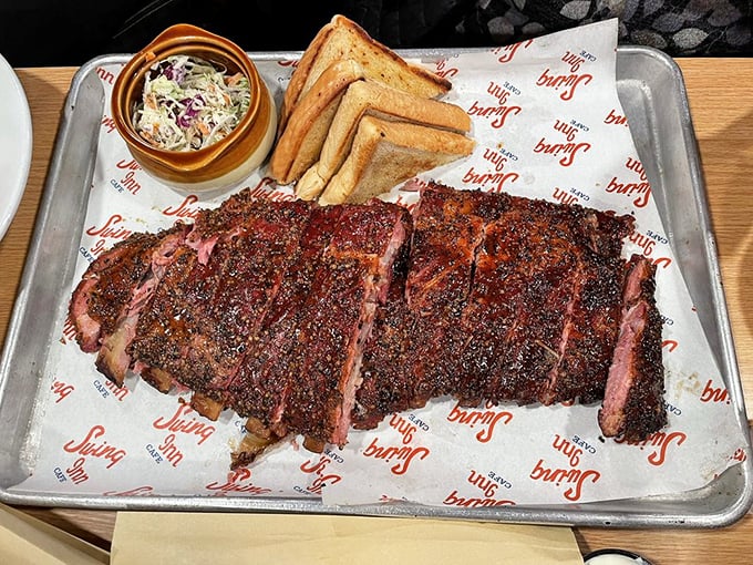 Barbecue so serious it comes on a metal tray—smoke-kissed ribs with that perfect bark that makes conversation stop and napkins necessary.
