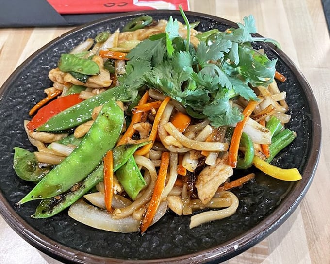 Stir-fried udon with vibrant vegetables—proof that eating your greens can be an adventure rather than a chore your mother nagged about.