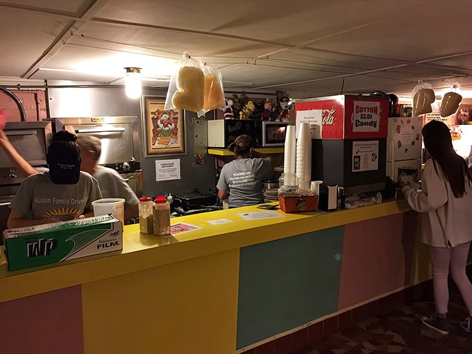 The concession counter buzzes with pre-show energy. That yellow countertop has supported countless elbows, popcorn tubs, and first-date butterflies.