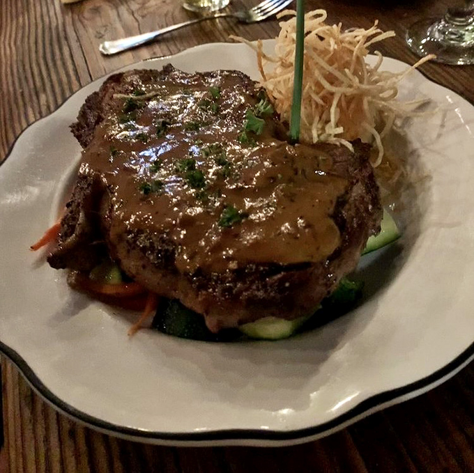 Not just a steak, but a declaration of love to beef – perfectly seared, sauced with reverence, and garnished with crispy shoestring potatoes.