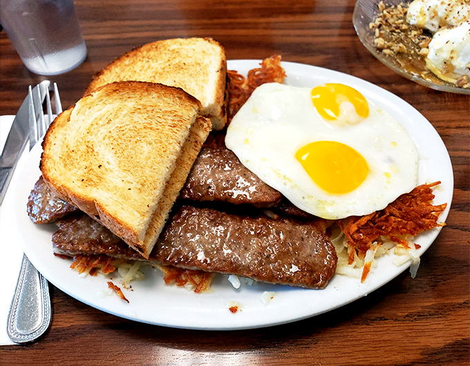 The breakfast of champions isn't cereal—it's this plate of sausage links, sunny-side-up eggs, and hash browns that could fuel a marathon.