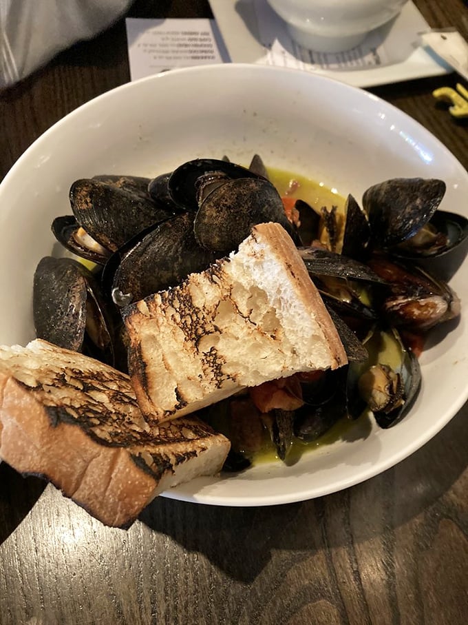 Steamed mussels that look like they're having a pool party in a broth so good you'll be requesting extra bread for strategic sopping operations.
