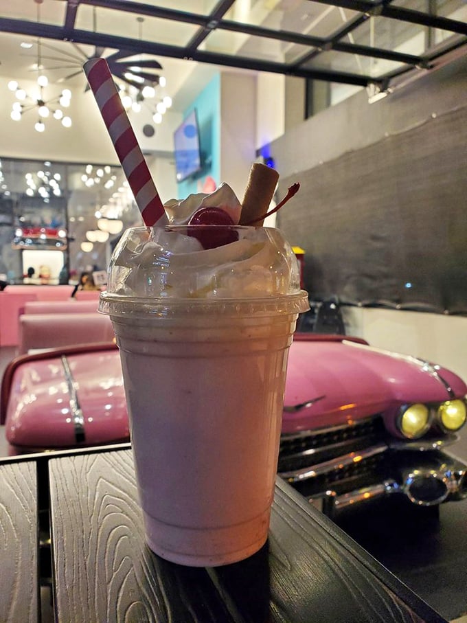 This isn't just a milkshake – it's a pink cloud of happiness with a straw, served alongside a classic car booth that makes Instagram influencers weak at the knees.