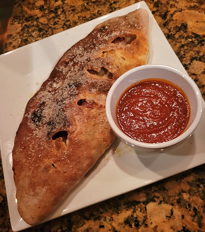 Half a golden stromboli with marinara sauce - because sometimes sharing feels optional.