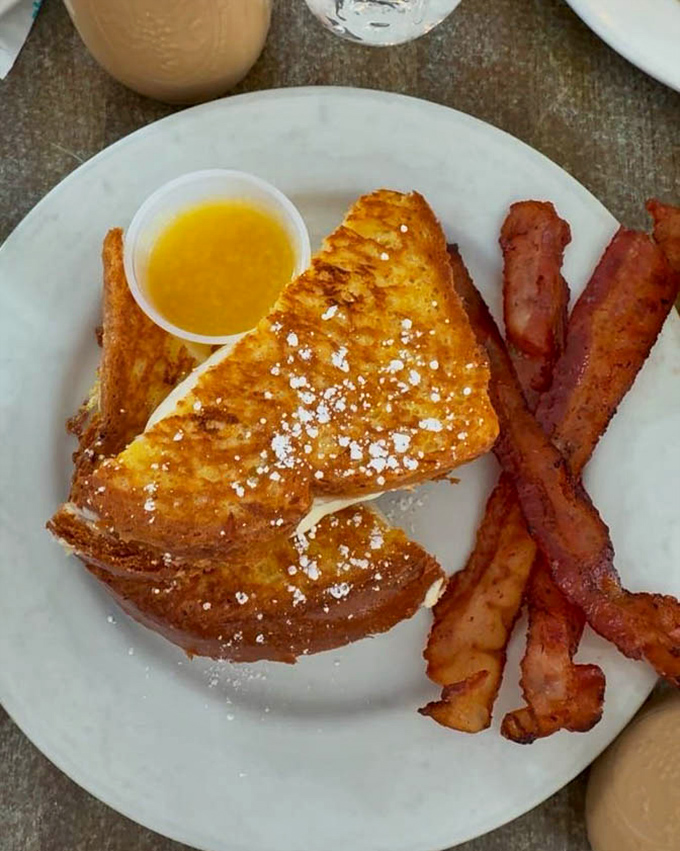 French toast that's dressed for success – crispy exterior, custardy interior, and bacon sidekicks that deserve their own spinoff show.