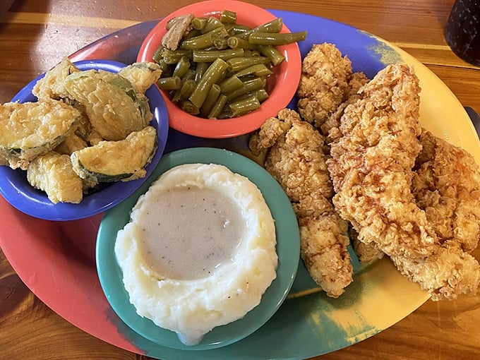Chicken tenders, mashed potatoes with gravy, green beans, and fried okra—a colorful plate that hits all the comfort food pleasure centers at once.