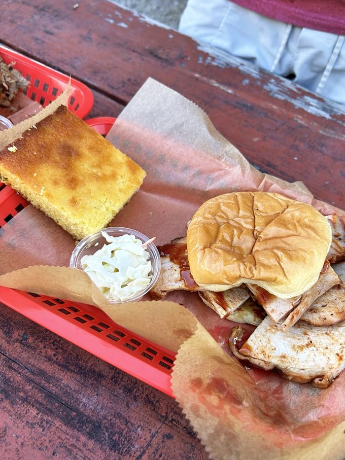 A golden-brown bun cradling tender meat with creamy slaw and mac and cheese—this tray is basically the barbecue equivalent of winning the lottery.