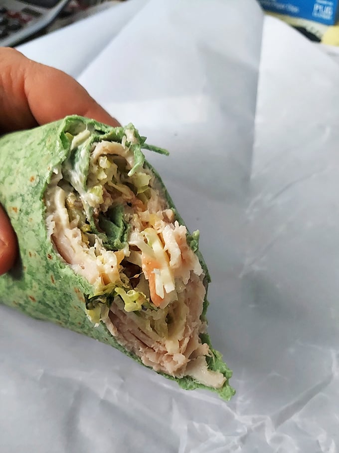 A wrap that's ready for its close-up! Layers of turkey and fresh veggies in a spinach tortilla—proof that healthy can still be indulgent.