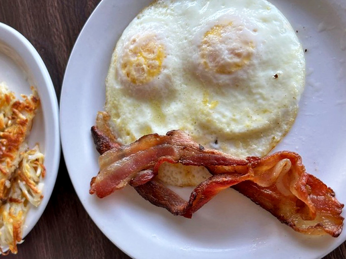 Two sunny-side up eggs with bacon that's achieved that magical state between crispy and chewy—the breakfast equivalent of hitting the lottery.