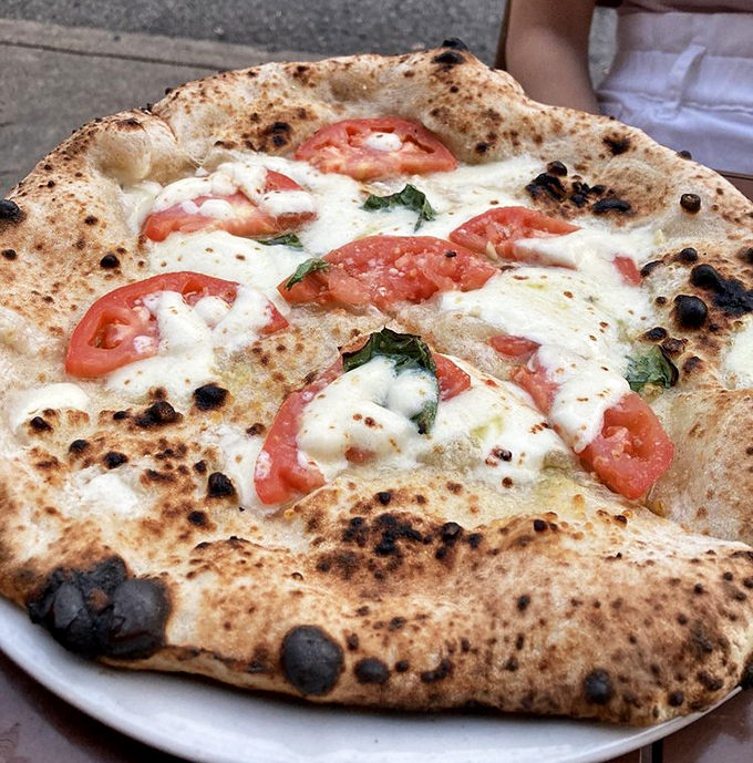 Fresh tomatoes and milky mozzarella on that blistered crust—the Bianca pizza is minimalism that maximizes flavor. Less is more, unless it's cheese.