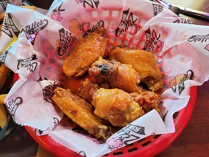 These wings aren't just cooked—they're transformed. Glistening with sauce and nestled in their basket, they're practically begging you to abandon all utensils and dignity.
