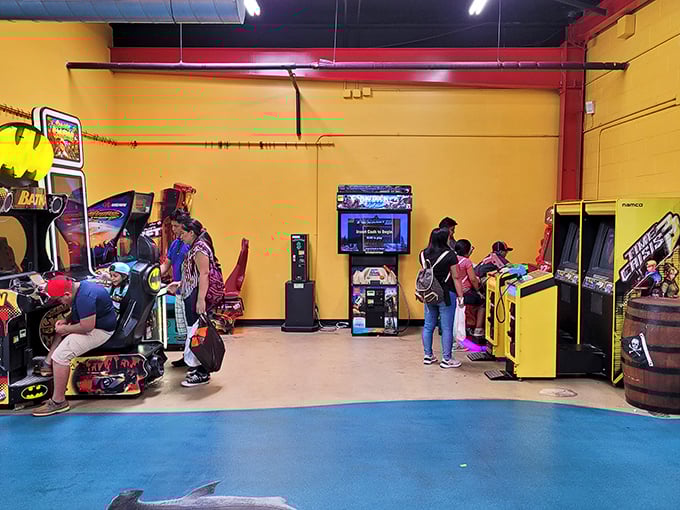 The arcade corner—where kids drag parents and parents rediscover their inner teenager through the universal language of "just one more game."