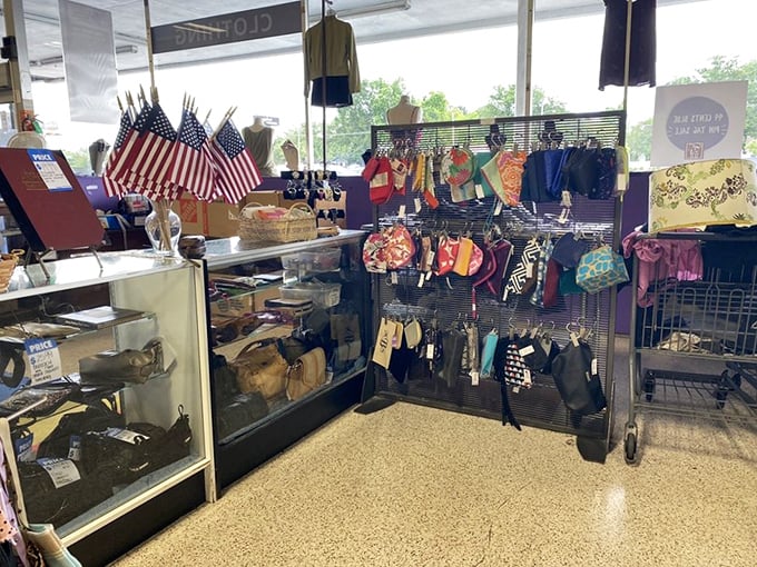 American flags stand at attention beside a collection of handbags—patriotism meets fashion in this corner of thrifting paradise. 