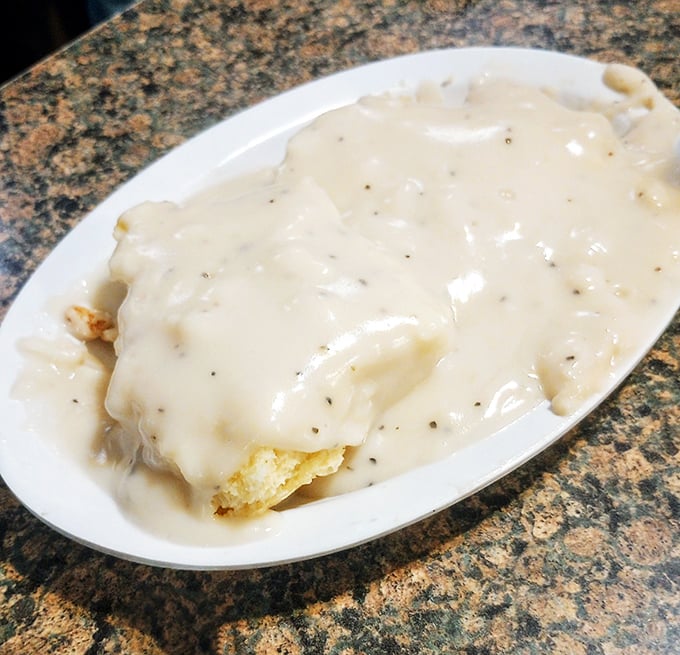 Biscuits swimming in creamy pepper gravy—the kind of breakfast that makes you want to take a nap immediately after finishing.