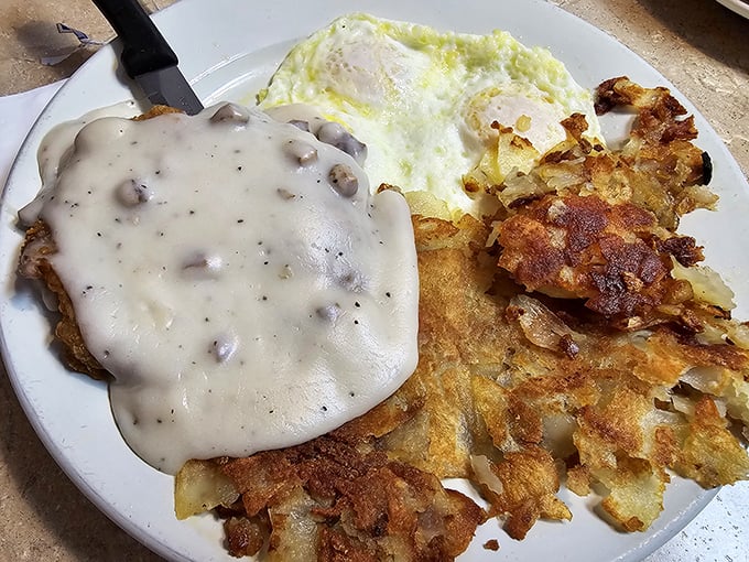 Gravity-defying hash browns topped with sausage gravy – proof that sometimes the best architecture in town isn't in buildings but on breakfast plates.