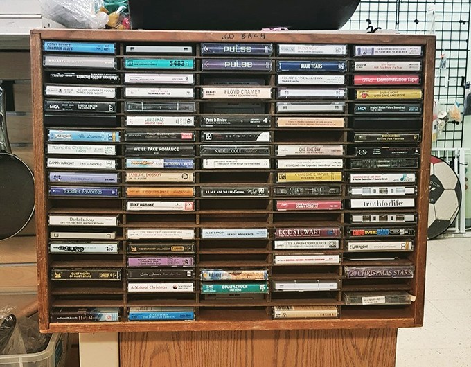 A wooden cassette display that's practically a museum exhibit. Gen Z calls this "vintage media" – the rest of us call it "Tuesday afternoons in 1988."