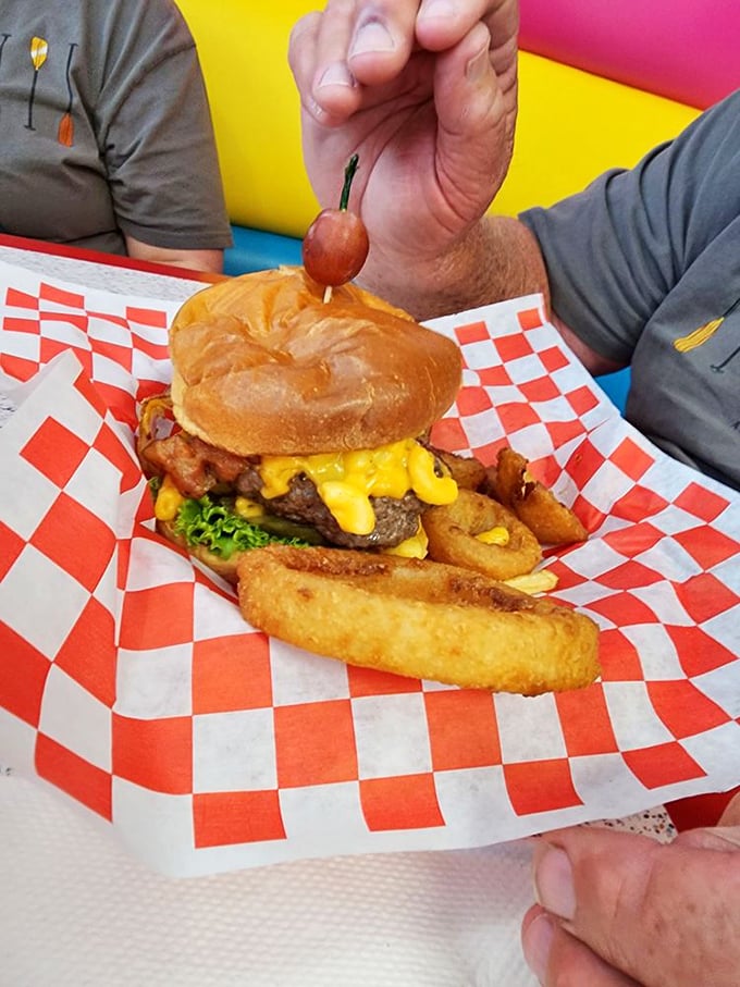 The burger arrives like a savory exclamation point—complete with melty cheese, crispy onion rings, and a cherry on top that says, "Yes, we're having fun here!" 