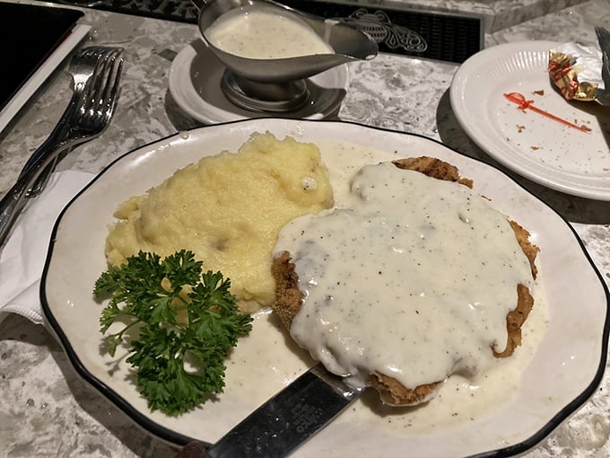 Country-fried steak smothered in peppery gravy alongside cloud-like mashed potatoes—comfort food elevated to an art form.