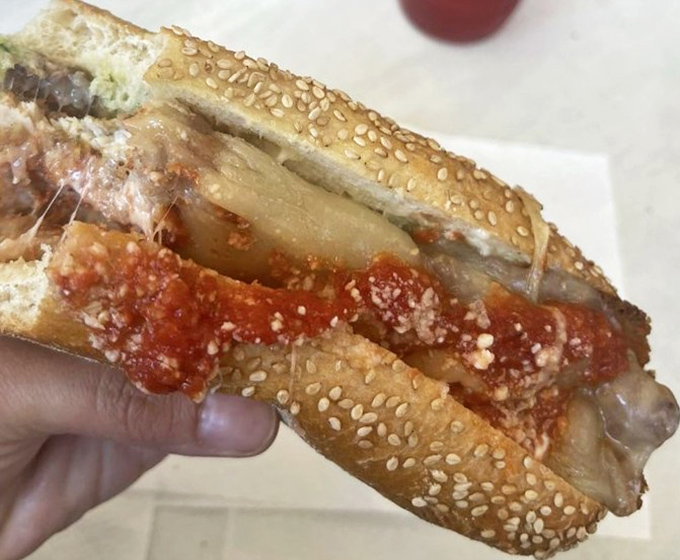 A chicken parm sandwich that would make any Italian grandmother nod in approval – crispy, saucy, cheesy perfection on a seeded roll.