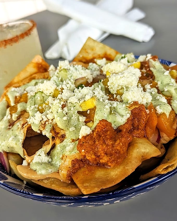 The legendary chili nachos—where every chip bears the perfect ratio of toppings. No sad, naked chips hiding at the bottom of this masterpiece.
