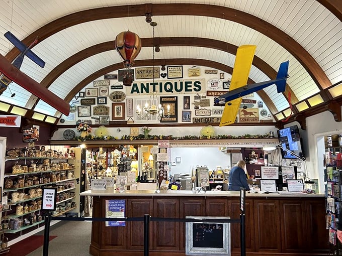 The front counter area, crowned with model airplanes and vintage signs, serves as mission control for this universe of collectibles.