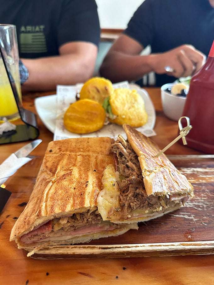 The Cuban sandwich that launched a thousand debates. Perfectly pressed, gloriously layered, and served with what appears to be tostones—this is Florida on a plate.
