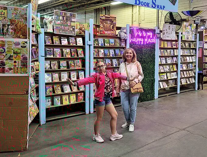 The universal expression of book-finding joy knows no age limit. That neon "happy place" sign in the background isn't just decoration—it's truth in advertising.