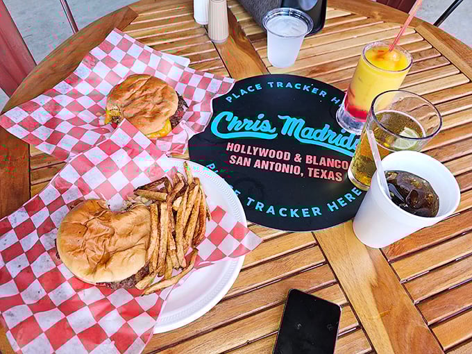 A perfect San Antonio afternoon: burgers, fries, and cold drinks on a wooden table that's witnessed countless "Oh my God" first bites.