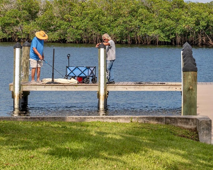 Two retirees living their best life – fishing off a dock where the biggest catch might just be the peaceful moment itself.