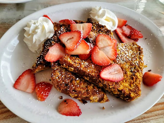 French toast that's having an identity crisis as dessert. Those strawberries aren't garnish – they're little red jewels of breakfast perfection.