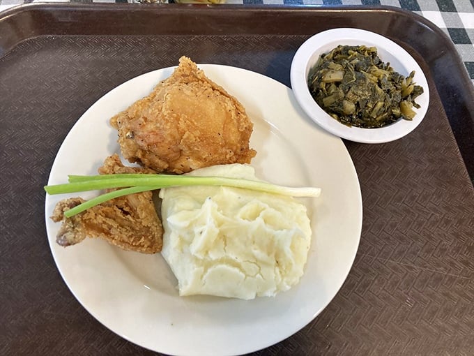 Golden fried chicken, creamy mashed potatoes, and collards—the holy trinity of Southern comfort on a no-nonsense plate.