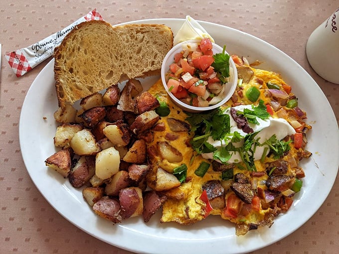 An omelet that refuses to be ignored, accompanied by potatoes that have achieved the perfect crisp-to-tender ratio—breakfast engineering at its finest.