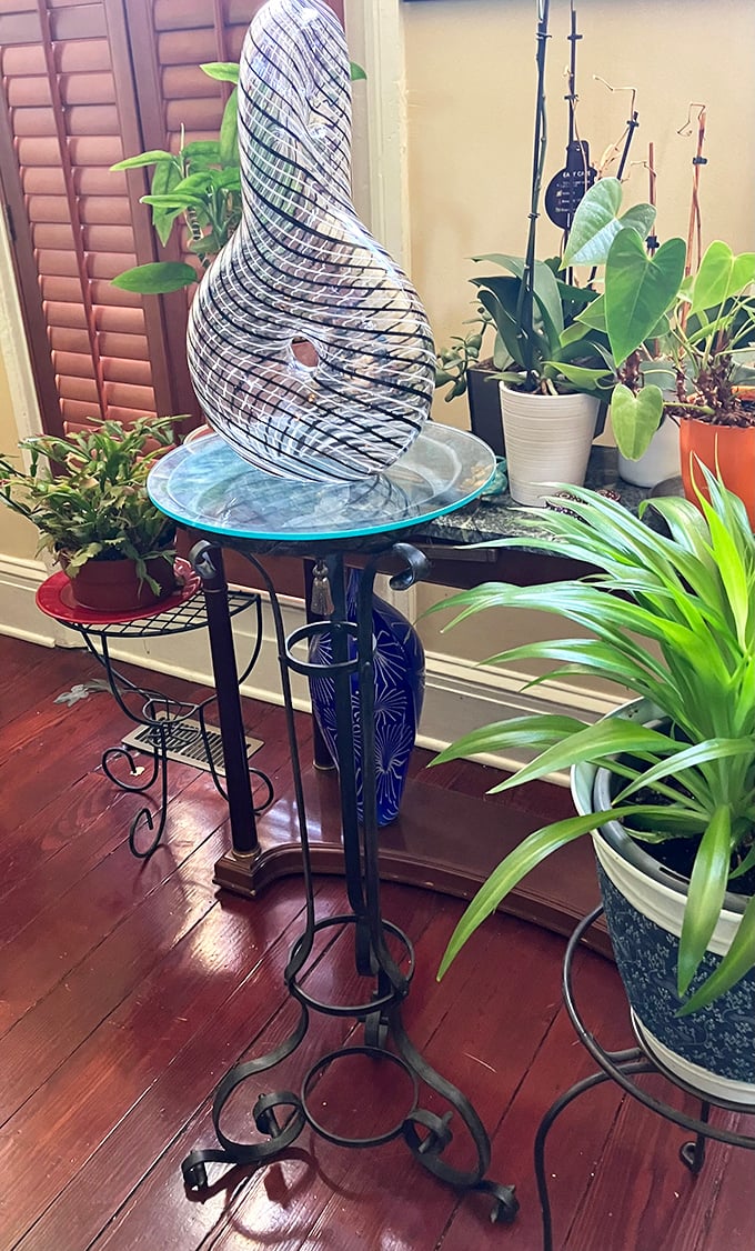 Nature meets nostalgia in this vignette. That swirling glass sculpture has probably witnessed more interesting dinner conversations than most people.