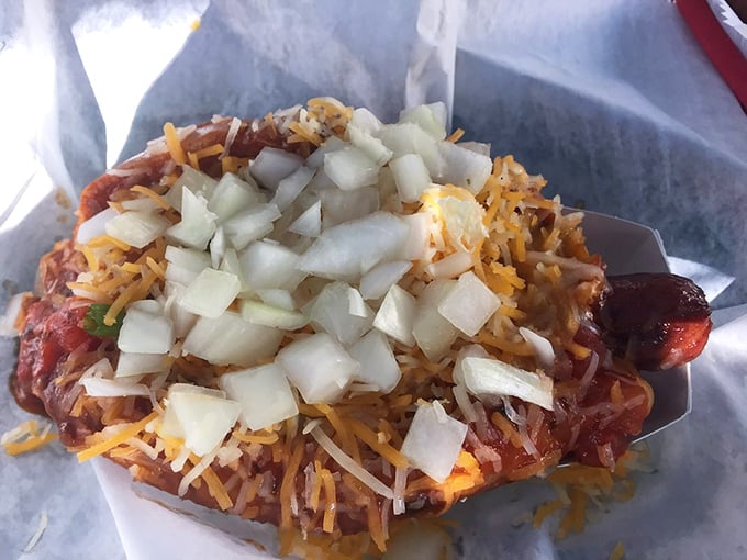This isn't just a hot dog—it's a flavor explosion topped with enough cheese and onions to make your cardiologist wince and your taste buds applaud.