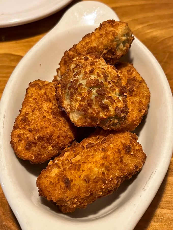 These golden-brown corn fritters aren't just appetizers – they're little orbs of cornmeal joy that make waiting for your entrée a pleasure, not a chore.