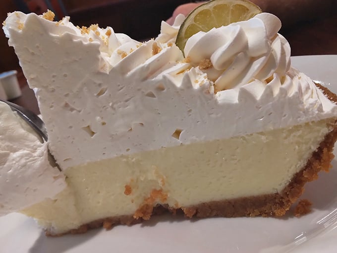 Key lime pie with a mountain of whipped cream—tangy, sweet, and tall enough to have its own zip code.