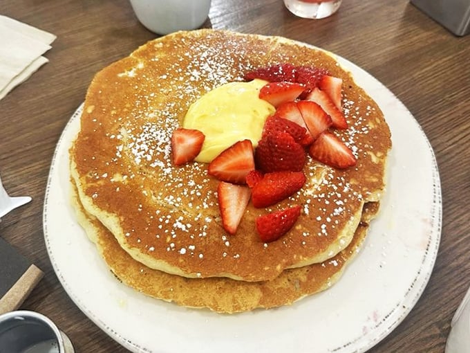 Golden pancakes adorned with fresh strawberries and a dollop of sunshine – proof that mornings can actually be something to celebrate.