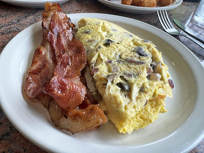 An omelet that doesn't skimp on fillings, paired with perfectly crisped bacon—this is breakfast that respects your hunger and your time.