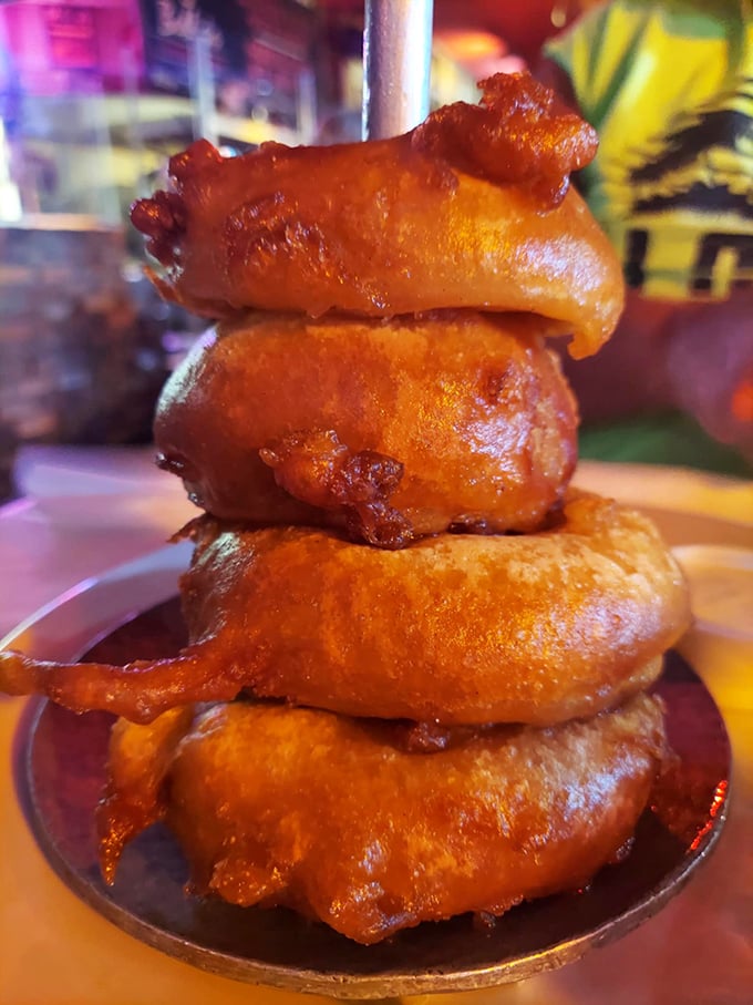 These aren't just onion rings – they're golden halos of crispy perfection stacked like the Tower of Pisa, only this tower is meant to topple straight into your mouth.