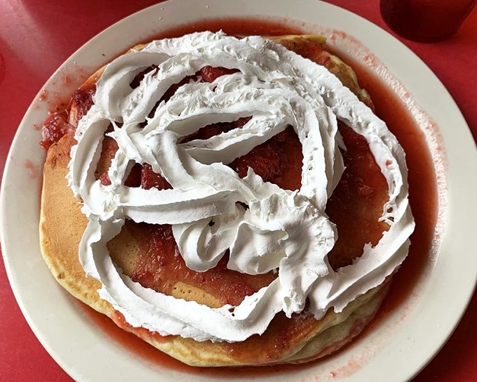 Pancakes crowned with whipped cream that could double as modern art—the kind of breakfast that makes you question why we ever invented lunch.