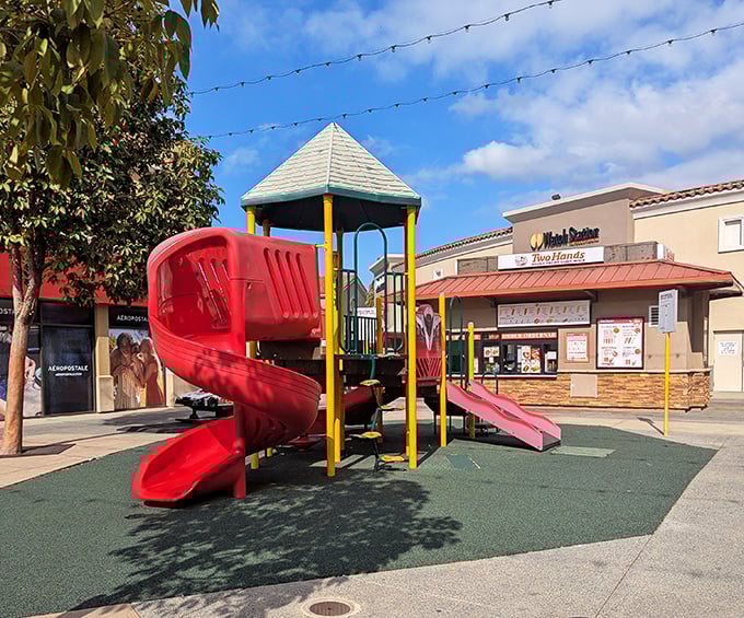 The unsung hero of outlet shopping – a playground oasis where kids burn energy while adults contemplate one more lap around the Nike store.