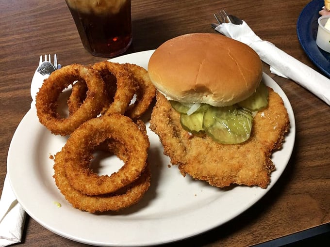 The legendary pork tenderloin—where the meat extends beyond the bun like Indiana's version of solar eclipse. Those onion rings aren't just sidekicks; they're co-stars.