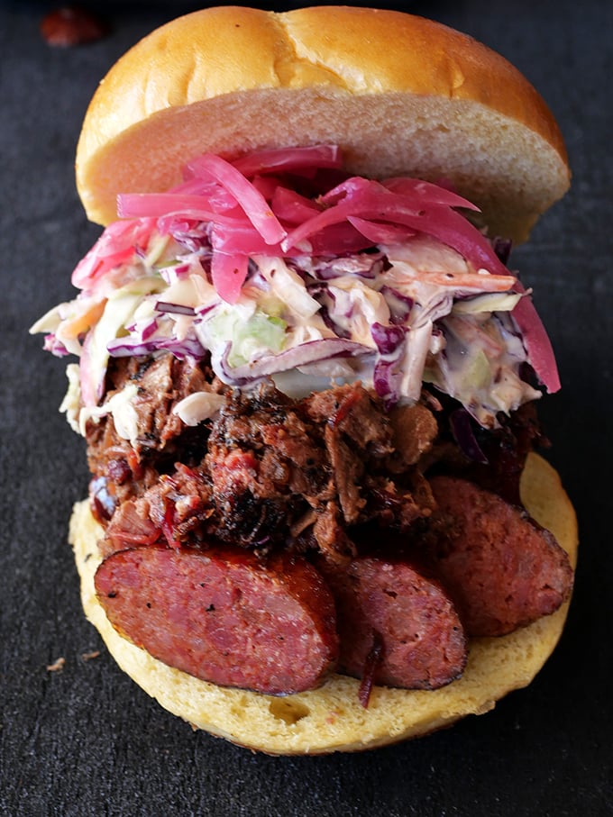 This sandwich doesn't just satisfy hunger—it's a towering achievement of meat, slaw, and pickled onions in perfect harmony.
