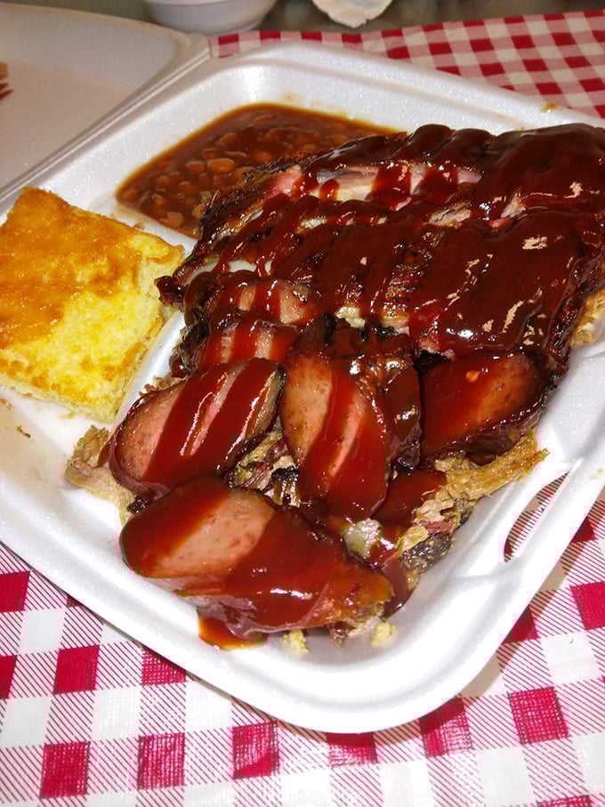 When barbecue sauce cascades over perfectly smoked sausages like this, you don't just eat lunch—you experience a meat epiphany. The cornbread is just there for moral support.